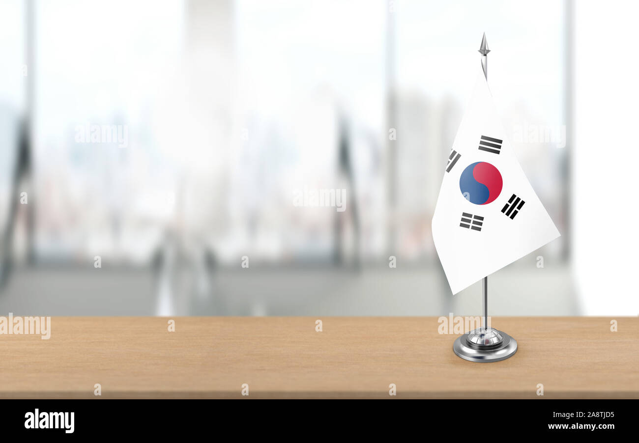 South Korean flag is standing on a metal pole is at wooden office table ...