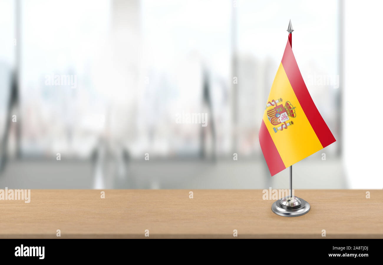Spanish flag is standing on a metal pole is at wooden office table ...