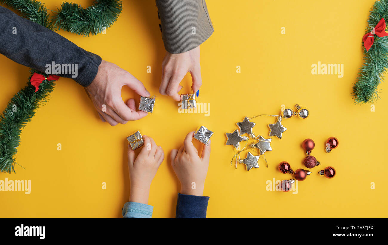 Top view of a family of four placing four mini presents on yellow ...
