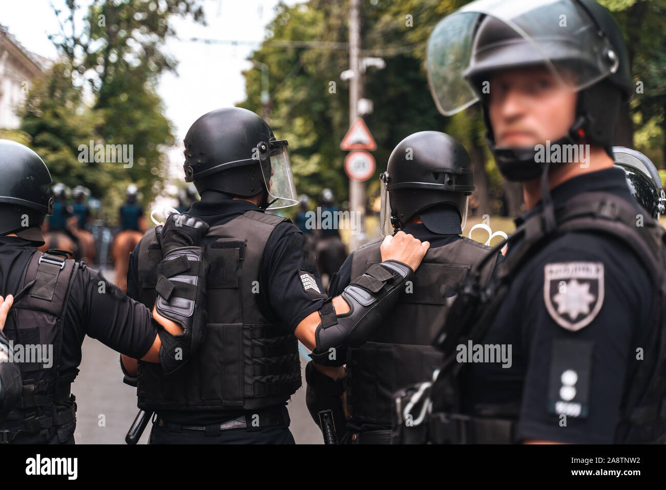 Squad policemen are on alert along city street. The police follow each ...