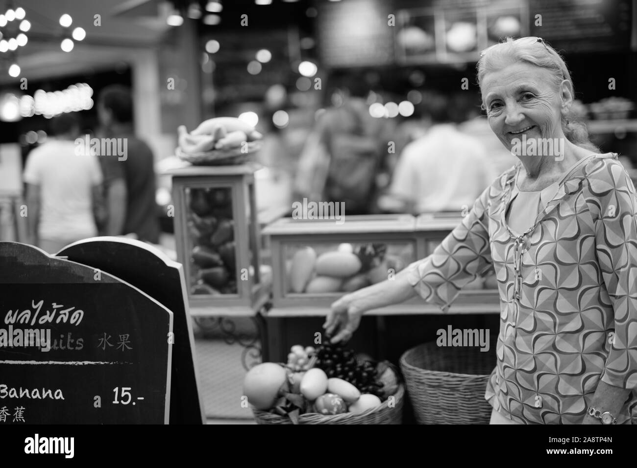 Beautiful senior tourist woman relaxing around the city in black and ...