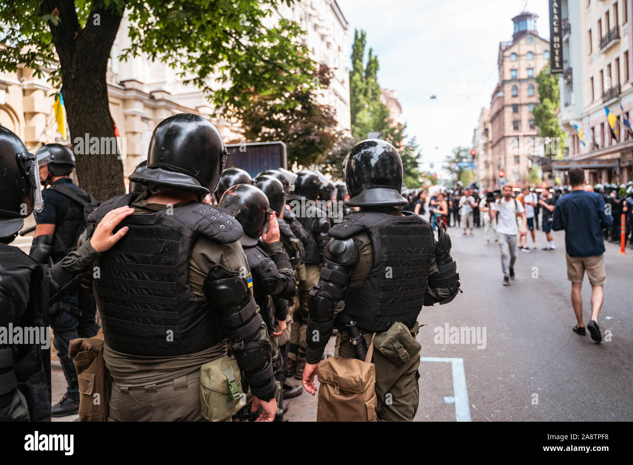 Squad policemen are on alert along city street. The police follow each ...