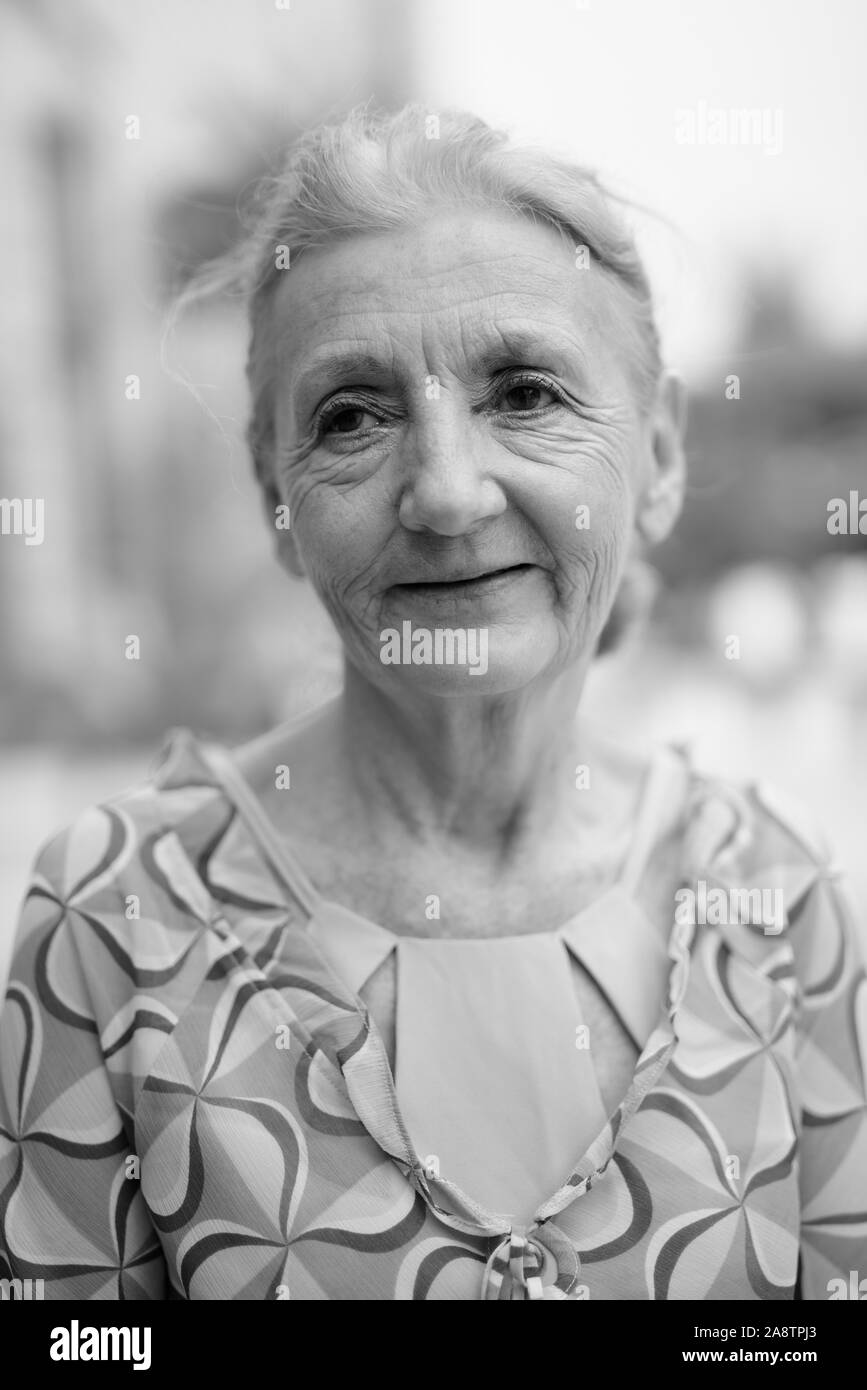 Beautiful senior tourist woman relaxing around the city in black and ...