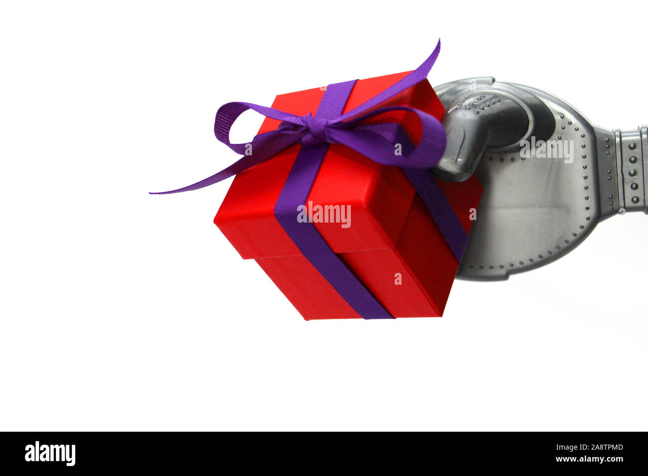 Robot hand holds a red gift box. The gift is tied with a beautiful ...