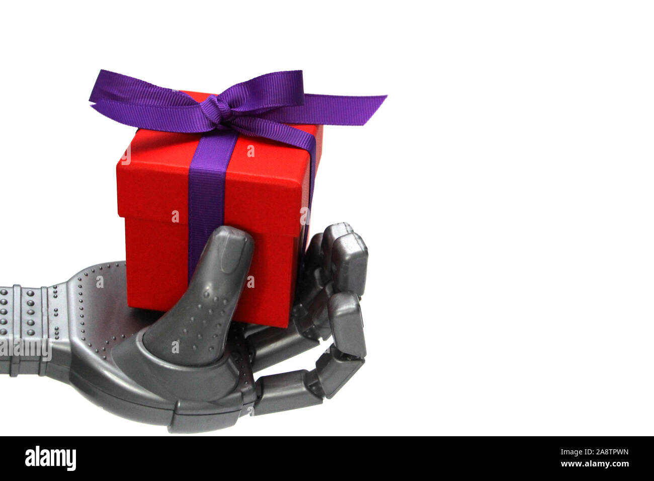 Robot hand holds a red gift box. The gift is tied with a beautiful ...