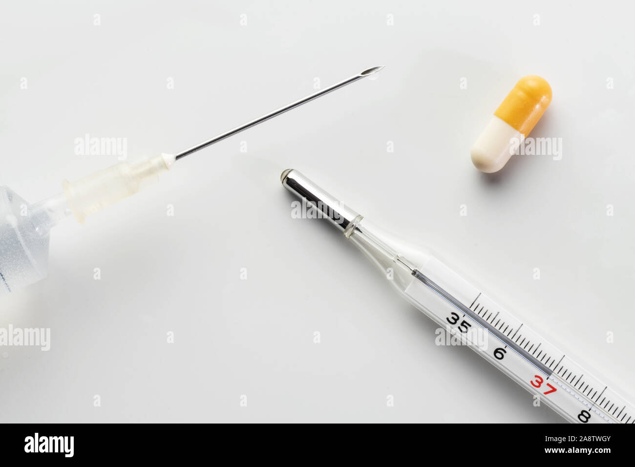 Medical syringe, mercury thermometer and pill capsule isolated on white ...