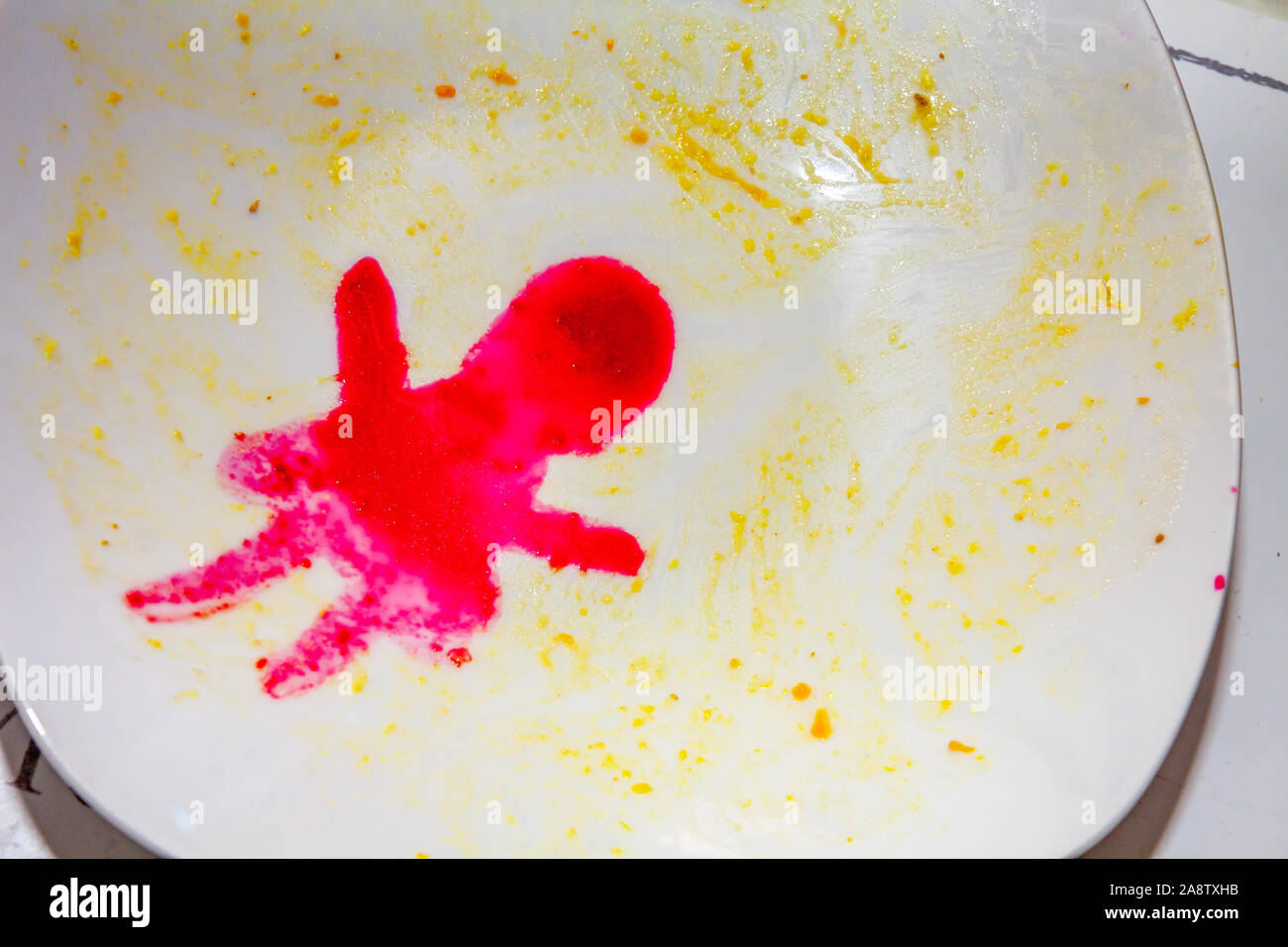 A dirty porcelain plate from with a childrens painting of beetroot ...