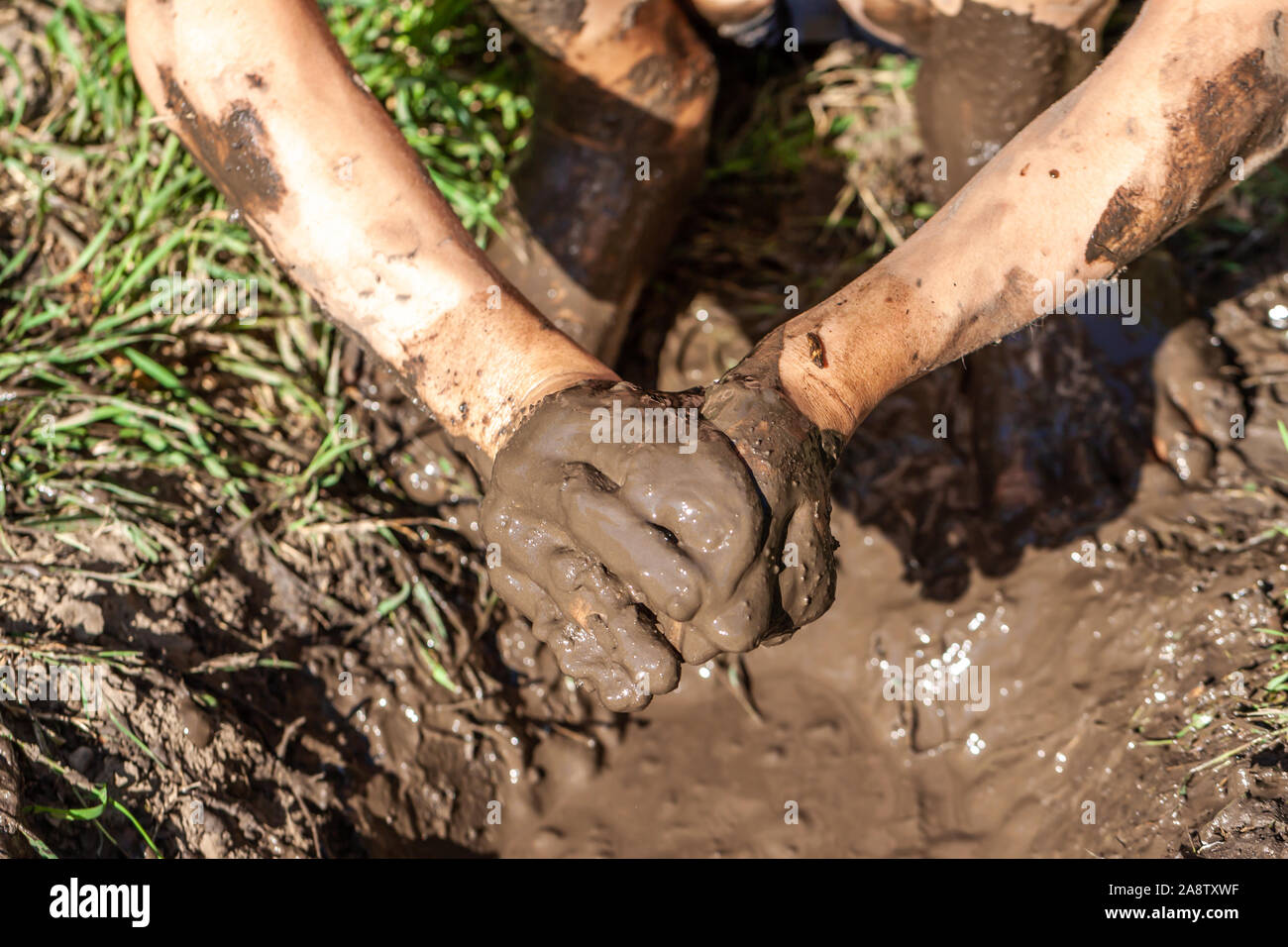 Boy working and playing in the mud Stock Photo - Alamy