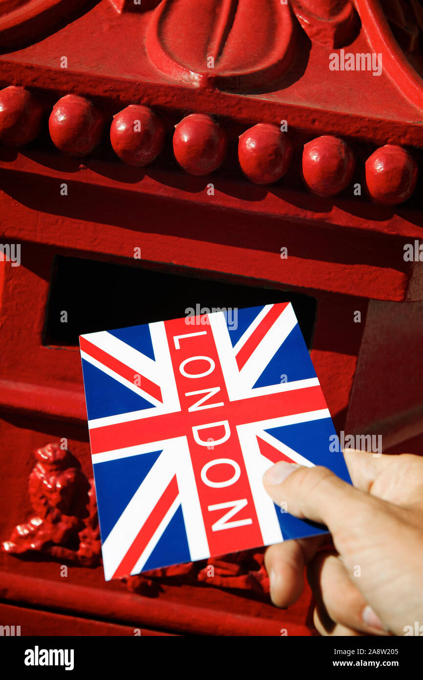 Hand placing a Union Jack British flag postcard into traditional bright ...