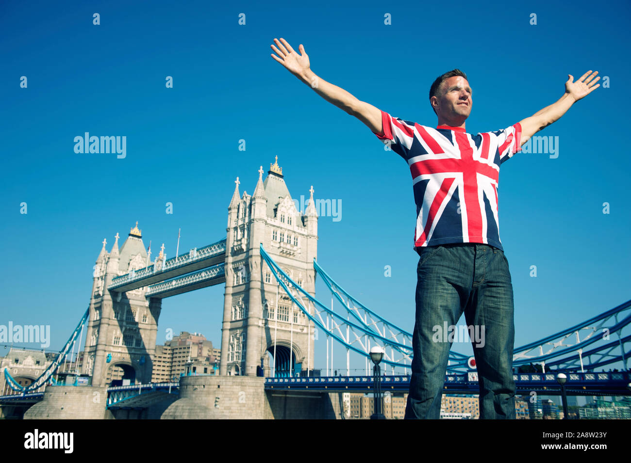 Patriotic young British man standing in a Union Jack T-shirt in front ...