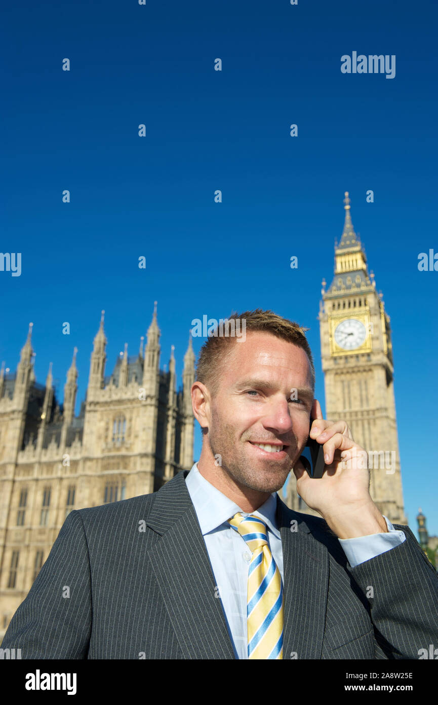 Smiling British politician talking on his mobile phone in front of the ...