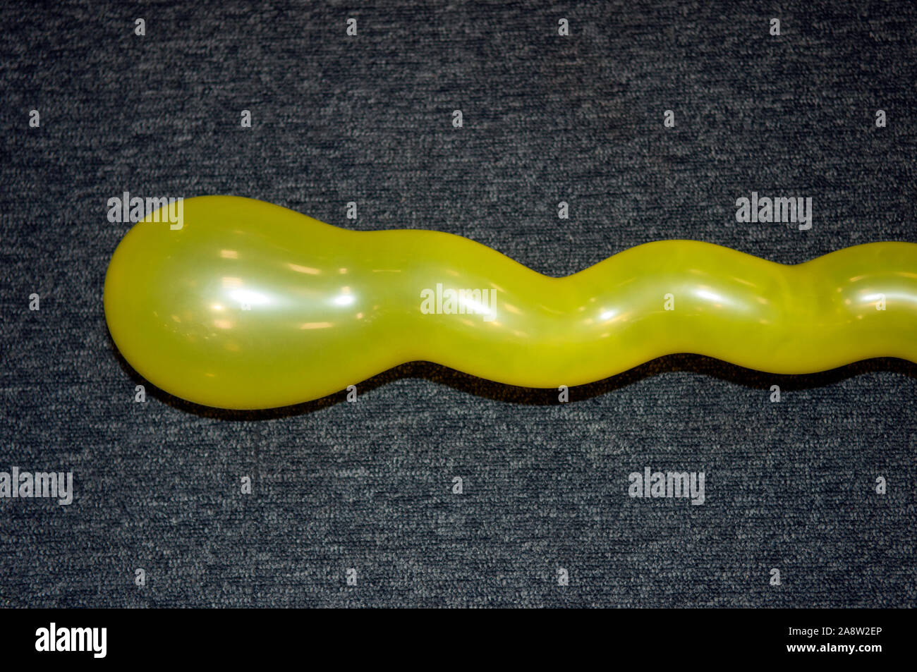 A Close Up Of An Inflated Yellow Party Balloon On A Carpeted Office ...