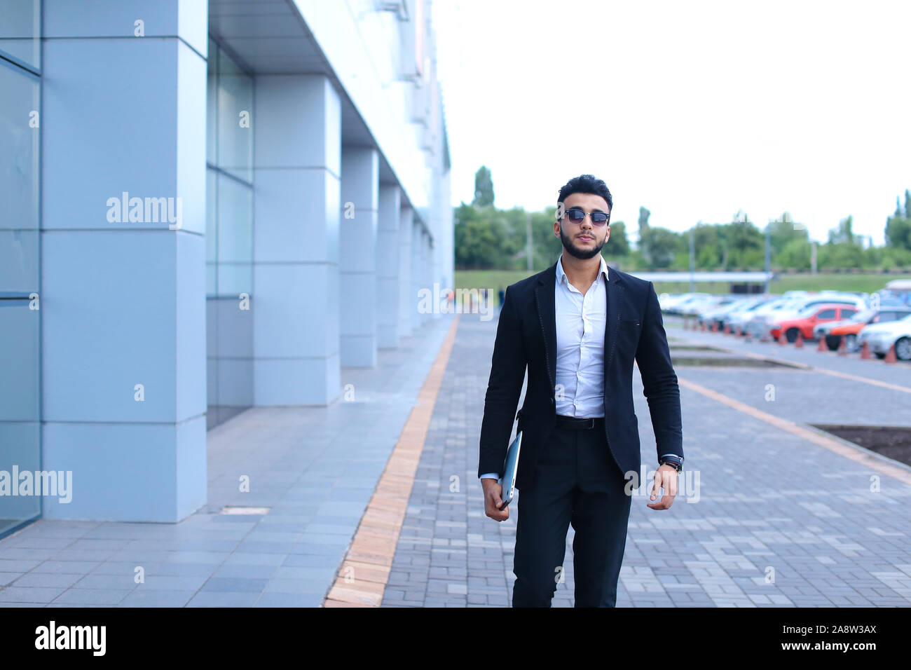 Arabic guy in business center stands smiling walking slow Stock Photo ...