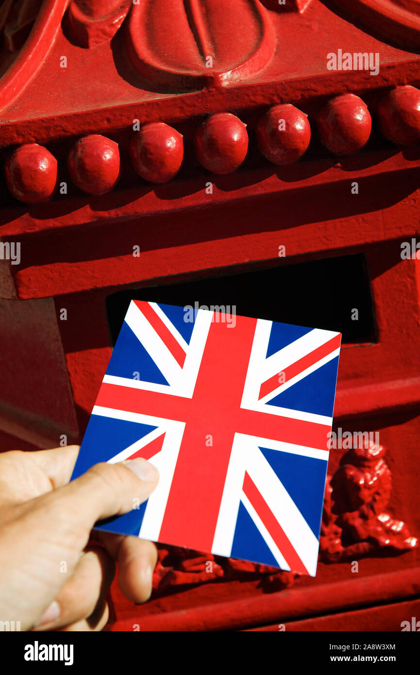 Hand placing a Union Jack British flag postcard into traditional bright ...