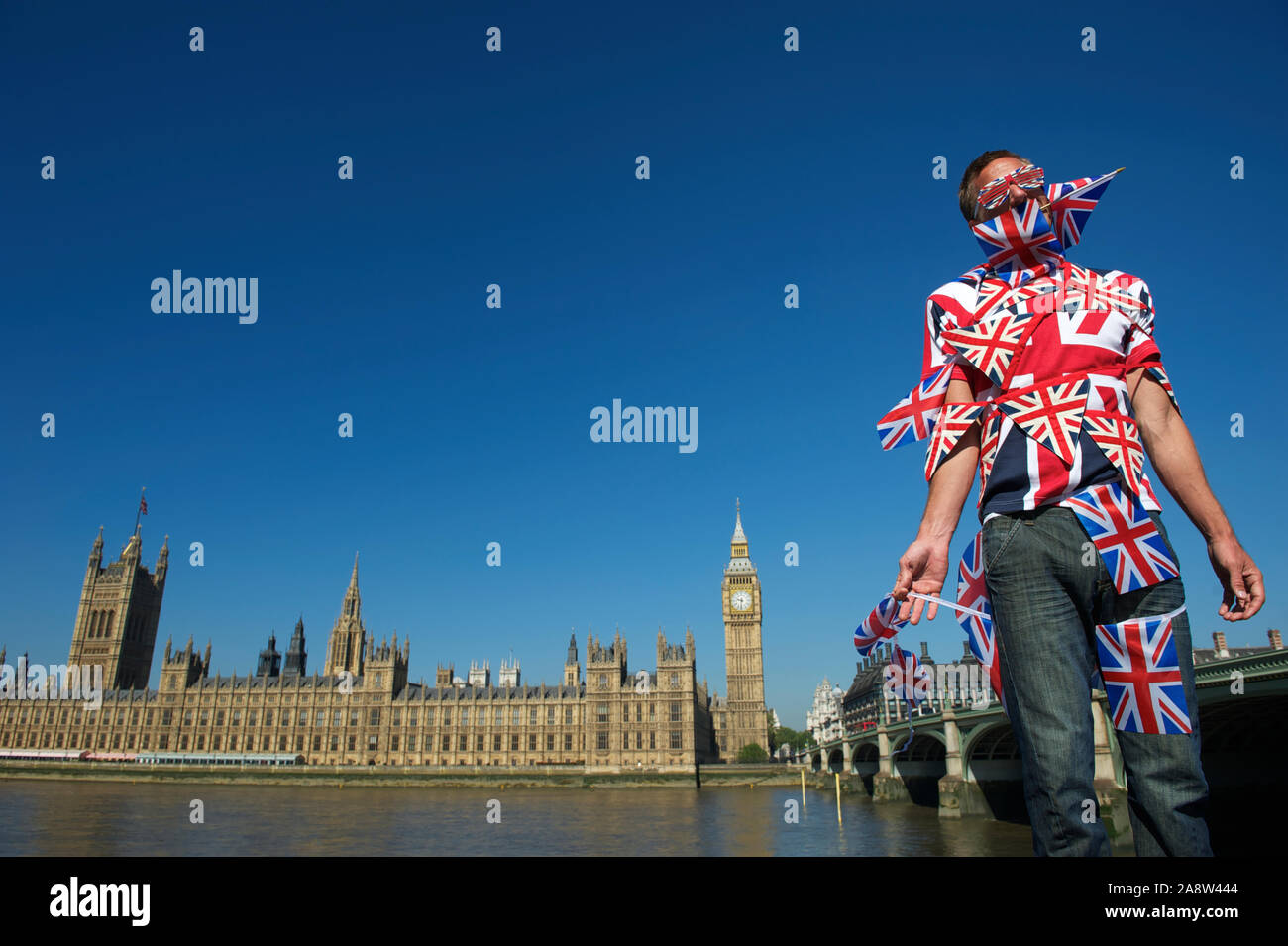 Unrecognizable man tangled in colorful Union Jack bunting standing in ...