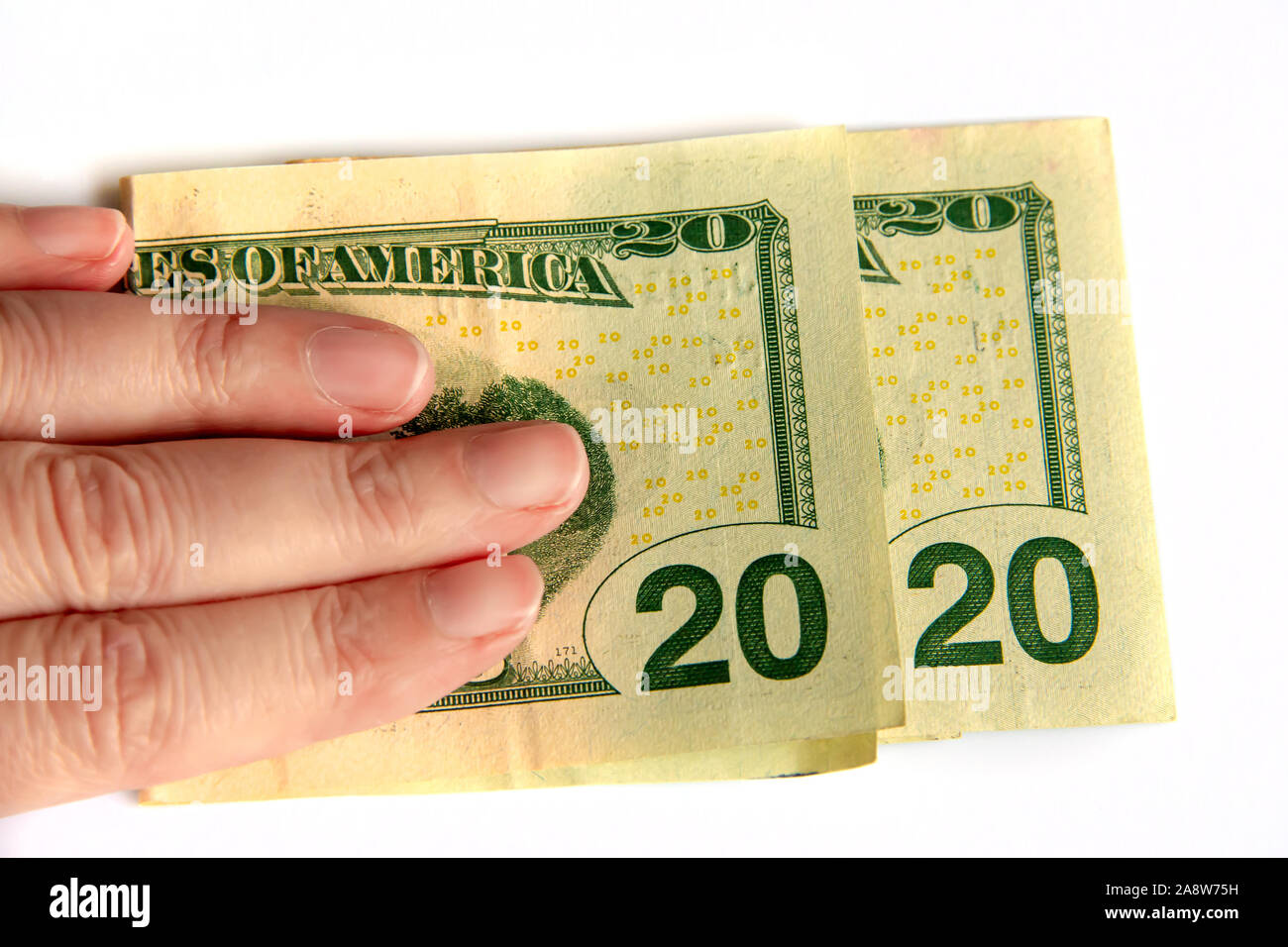 2020 written with dollars bank notes in a hand isolated on white ...
