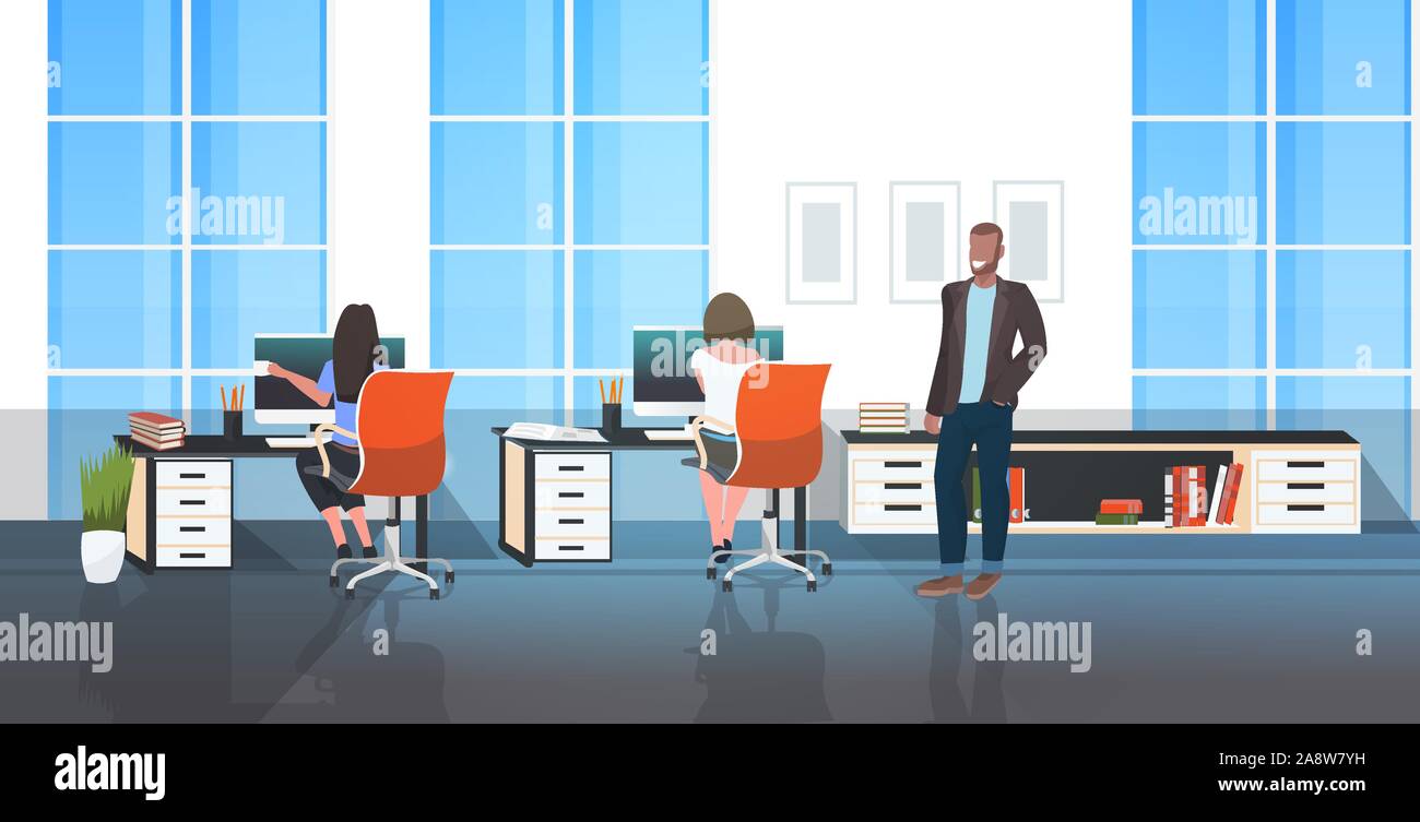 male boss walking through the office and controlling female workers ...