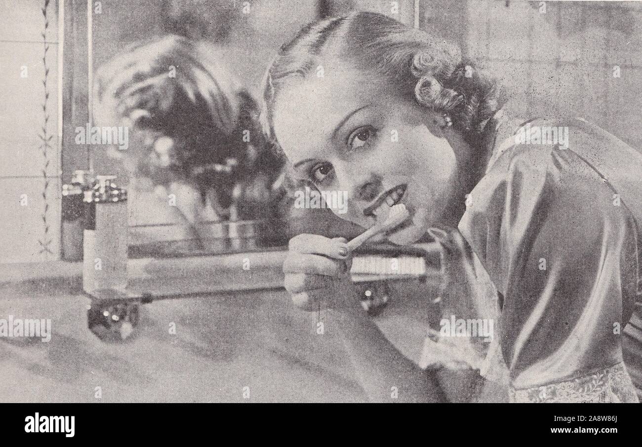 A woman using a toothbrush made of 'Exton' nylon bristles 1940s / 1950s ...