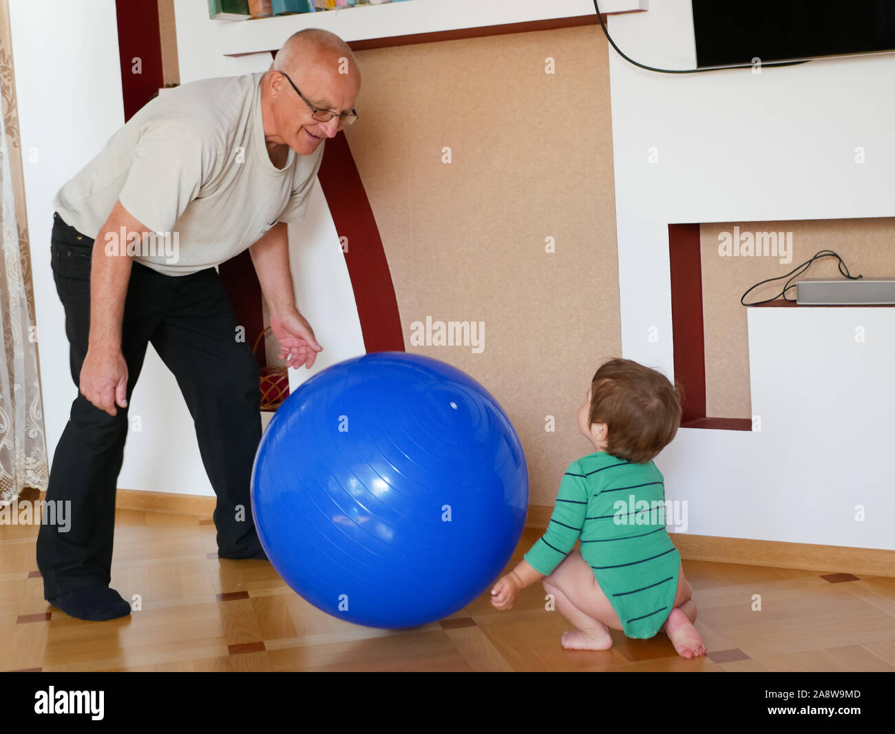 Grandfather plays ball with his grandson. The relationship between ...