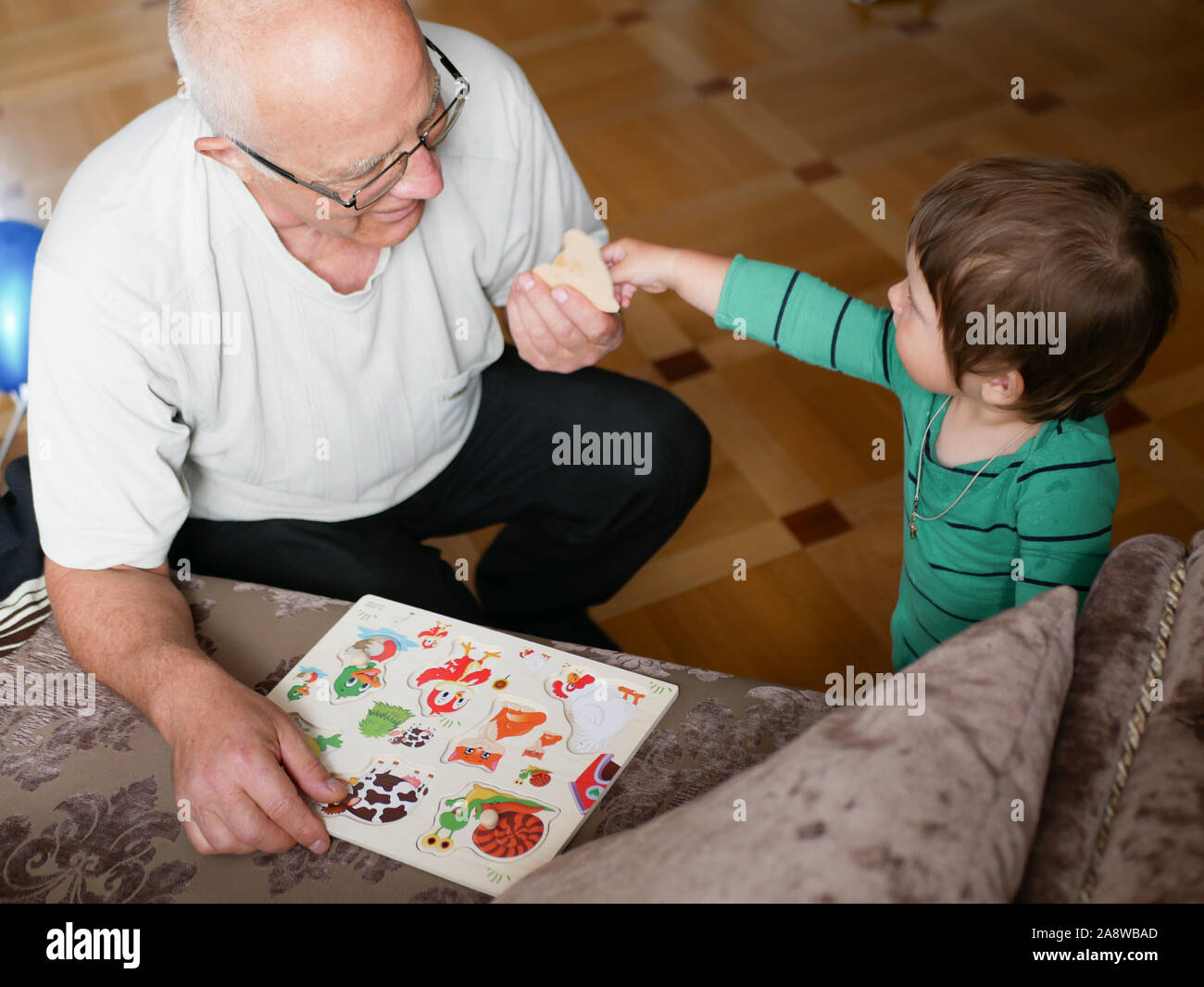 Grandfather plays with his grandson at home. Grandfather and grandson ...