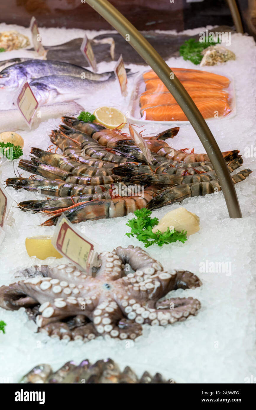 Fresh seafood on ice in farmers market. Sale of shrimps, fish, octopus ...