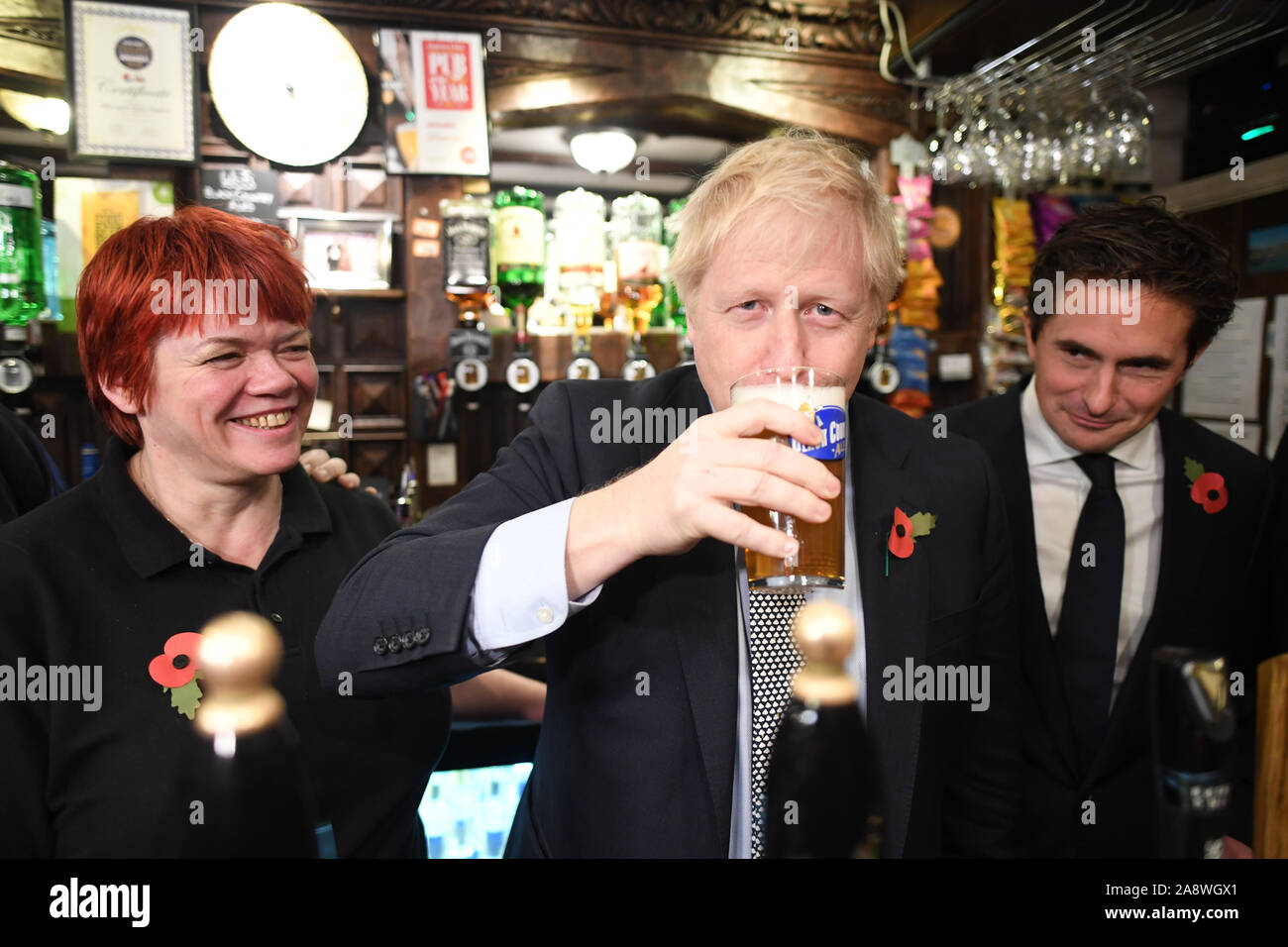 Prime Minister Boris Johnson, drinks from a pint watched by Defence ...