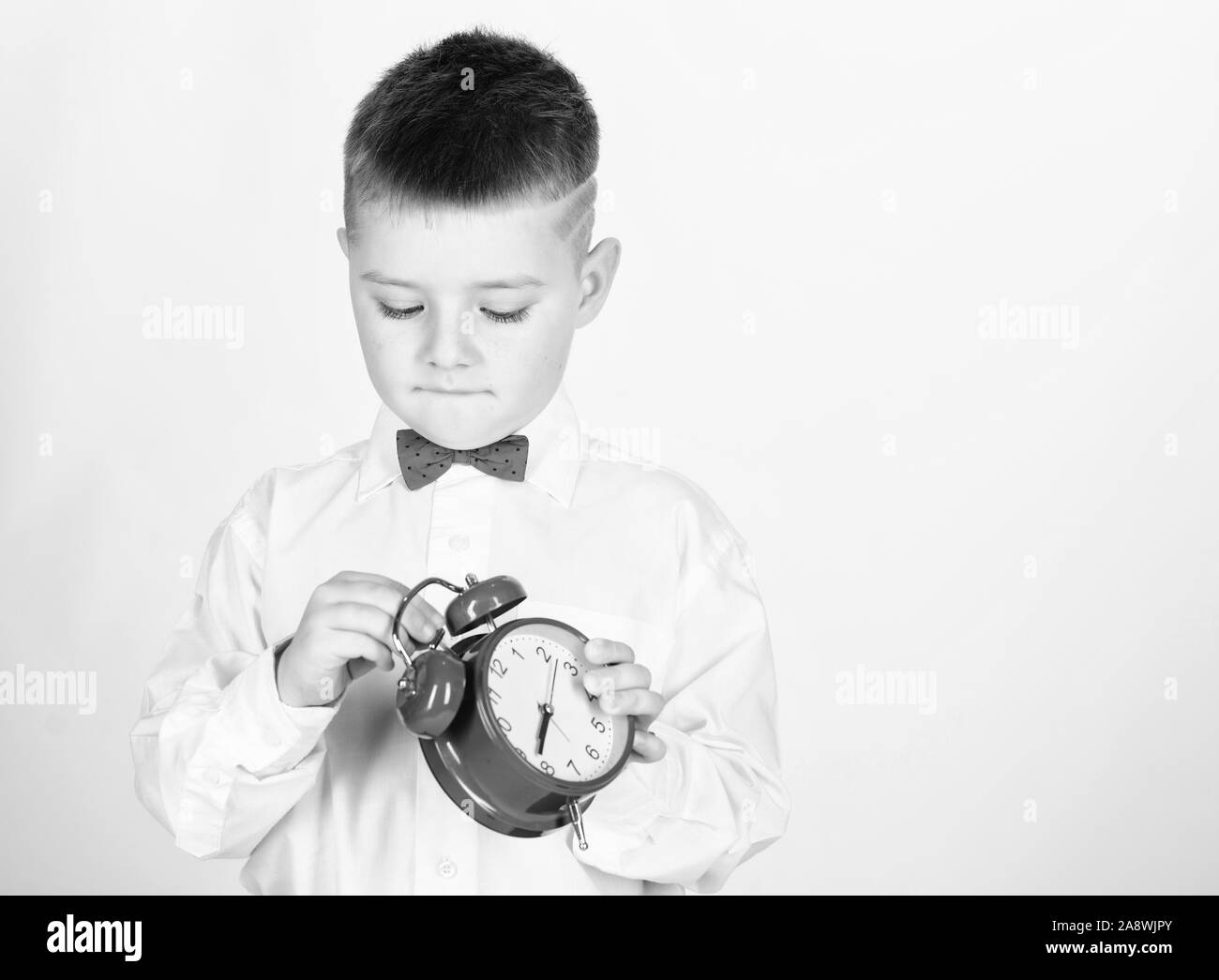 Child little boy hold red clock. It is time. Morning routine. Schoolboy ...