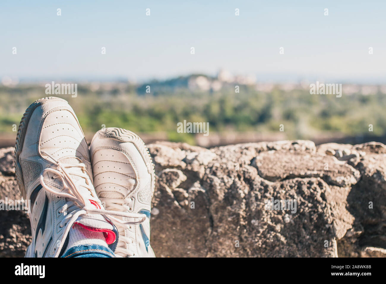 Rest resting feet on a stone wall - halt after a long walk Stock Photo ...