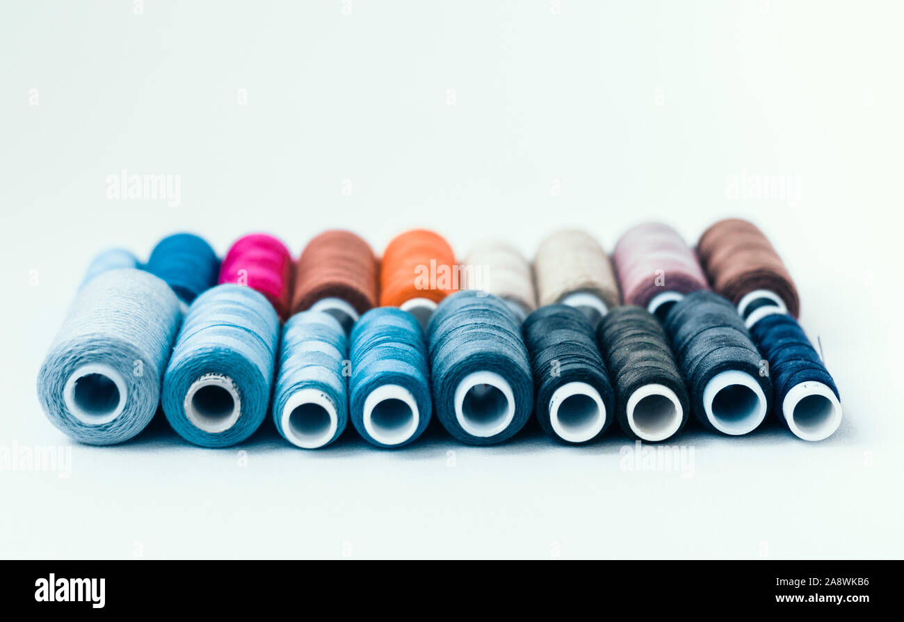 Colored sewing thread coils on white background with copy space for ...