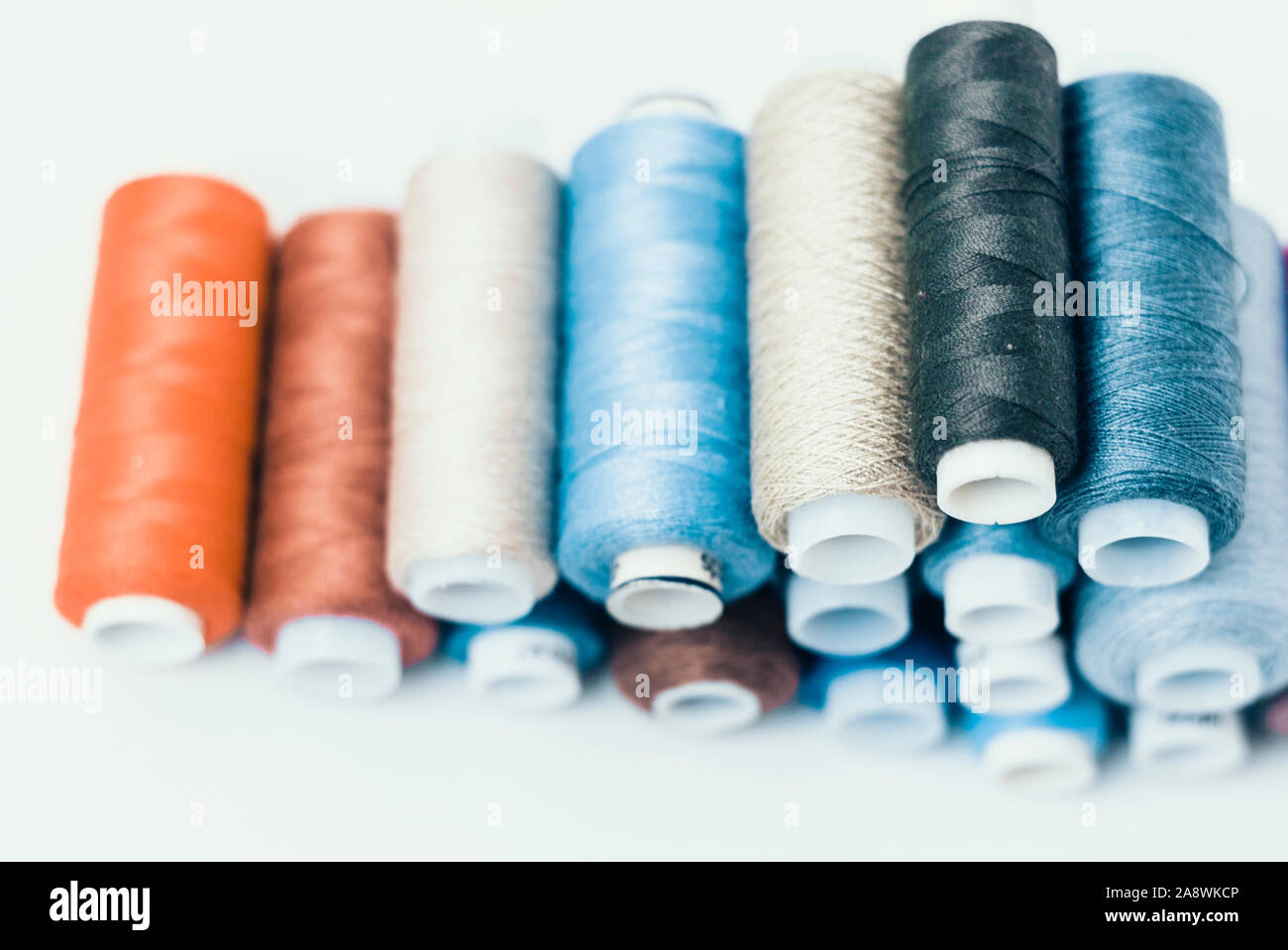 Colored sewing thread coils on white background with copy space for ...