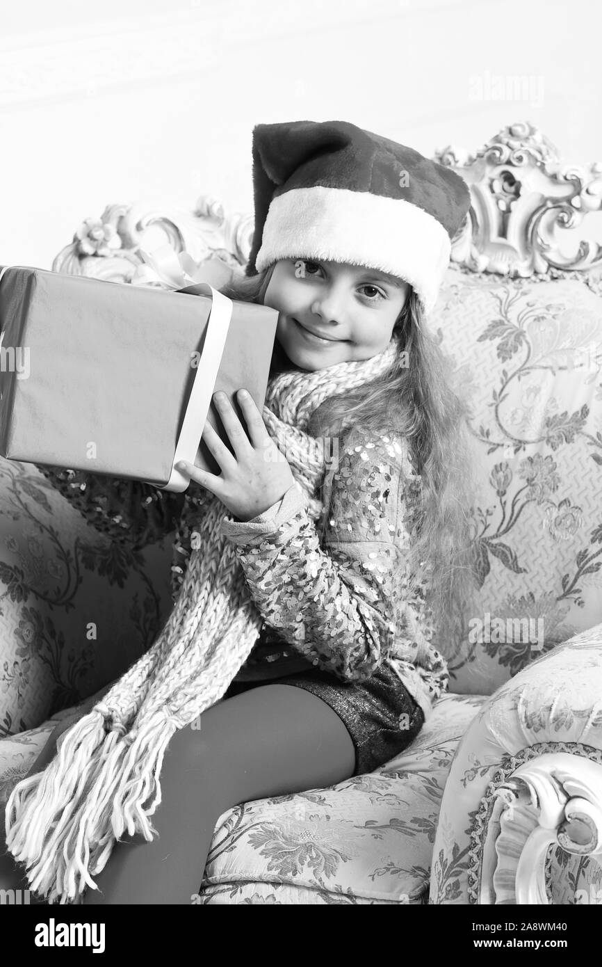 Christmas time and surprise concept. Santas helper in red hat sits on ...