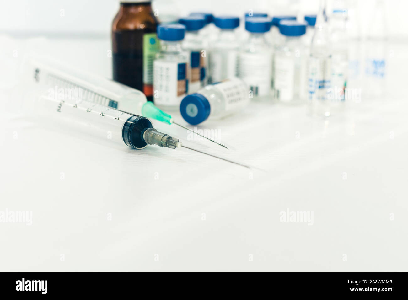 Medicine bottles, ampules and syringes on white background with copy ...