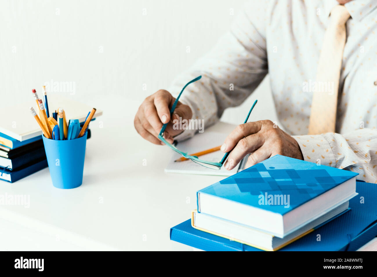 Close-up of hands middle-aged man in white shirt typing on keyboard ...
