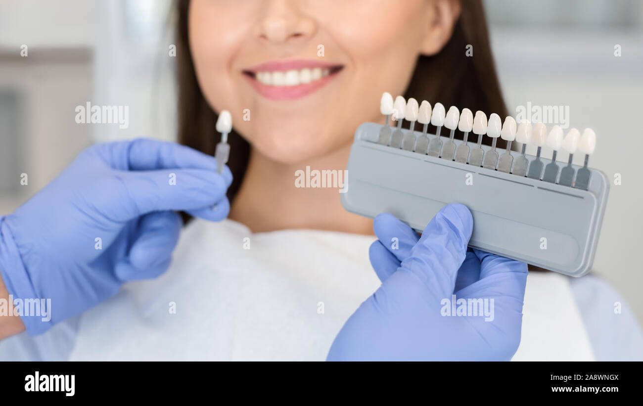Doctor applying sample from tooth scale to smiling patient teeth Stock ...