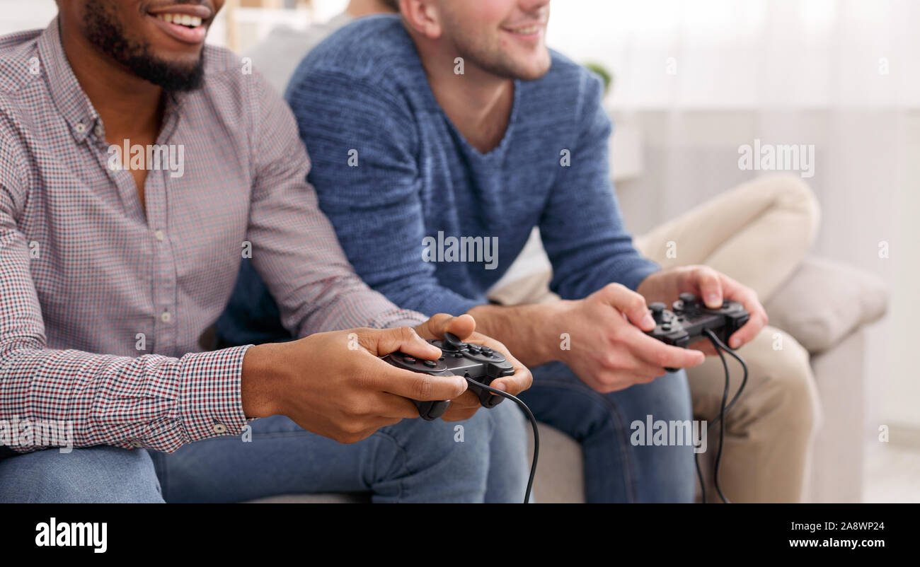 Two mates holding joysticks, playing video games Stock Photo - Alamy