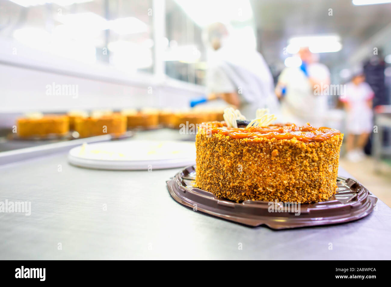 Workers confectioners make biscuit cakes with puff pastry with ...