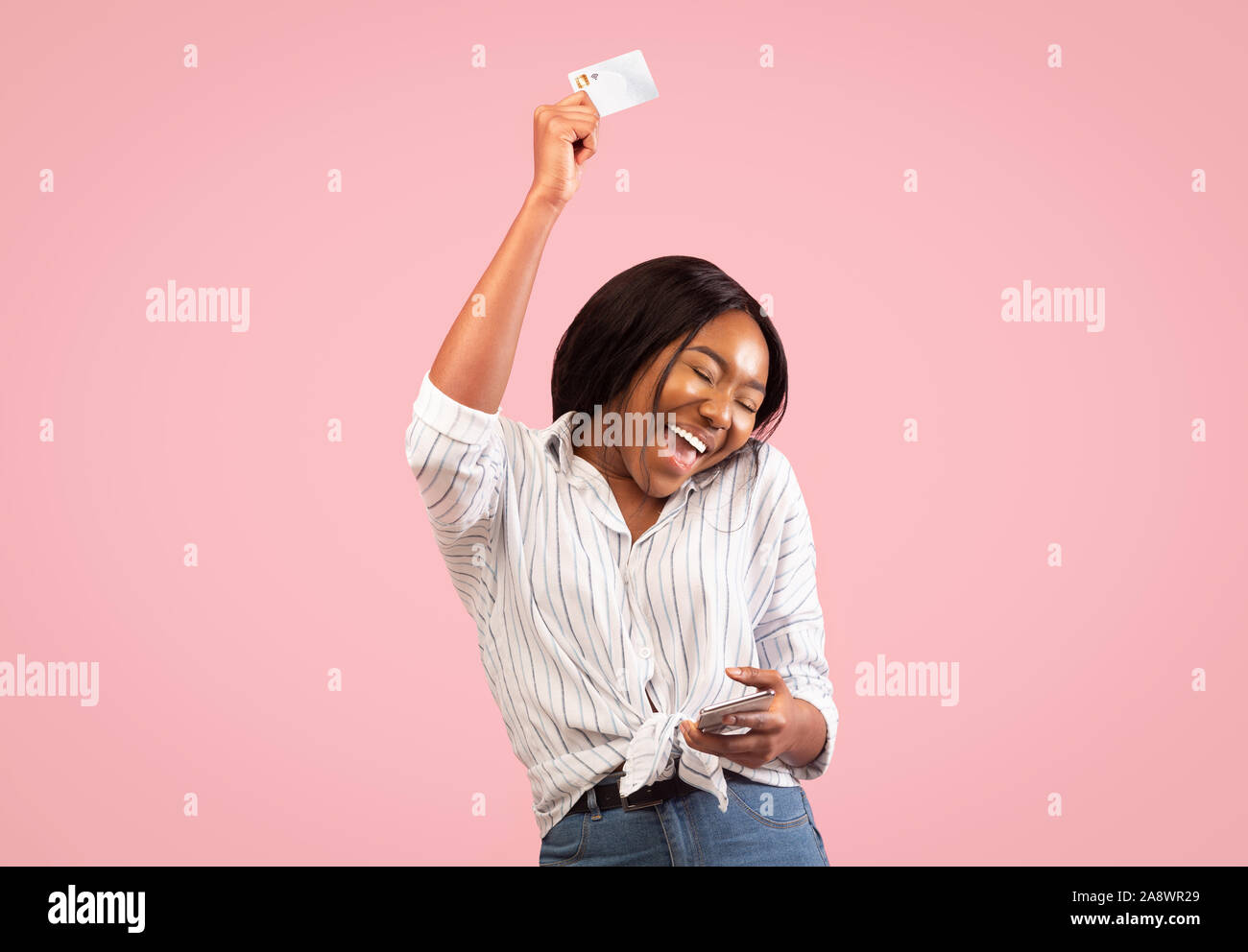 Happy Girl Dancing Holding Phone And Credit Card, Studio Shot Stock ...