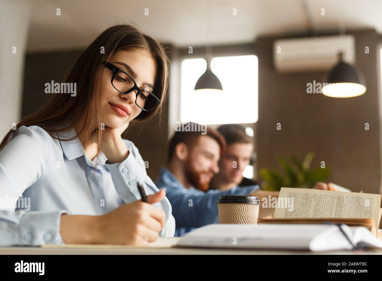Smart girl student studying at library, writing essay Stock Photo - Alamy