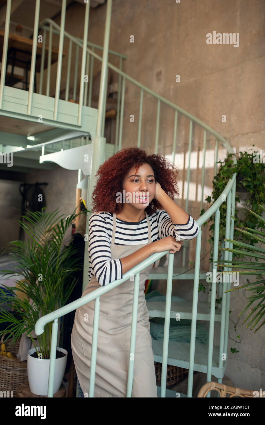 Curly woman standing on stairs in her own cafeteria Stock Photo - Alamy