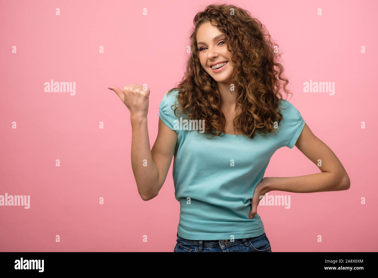 Pretty girl point her finger to left side of the picture isolated on ...