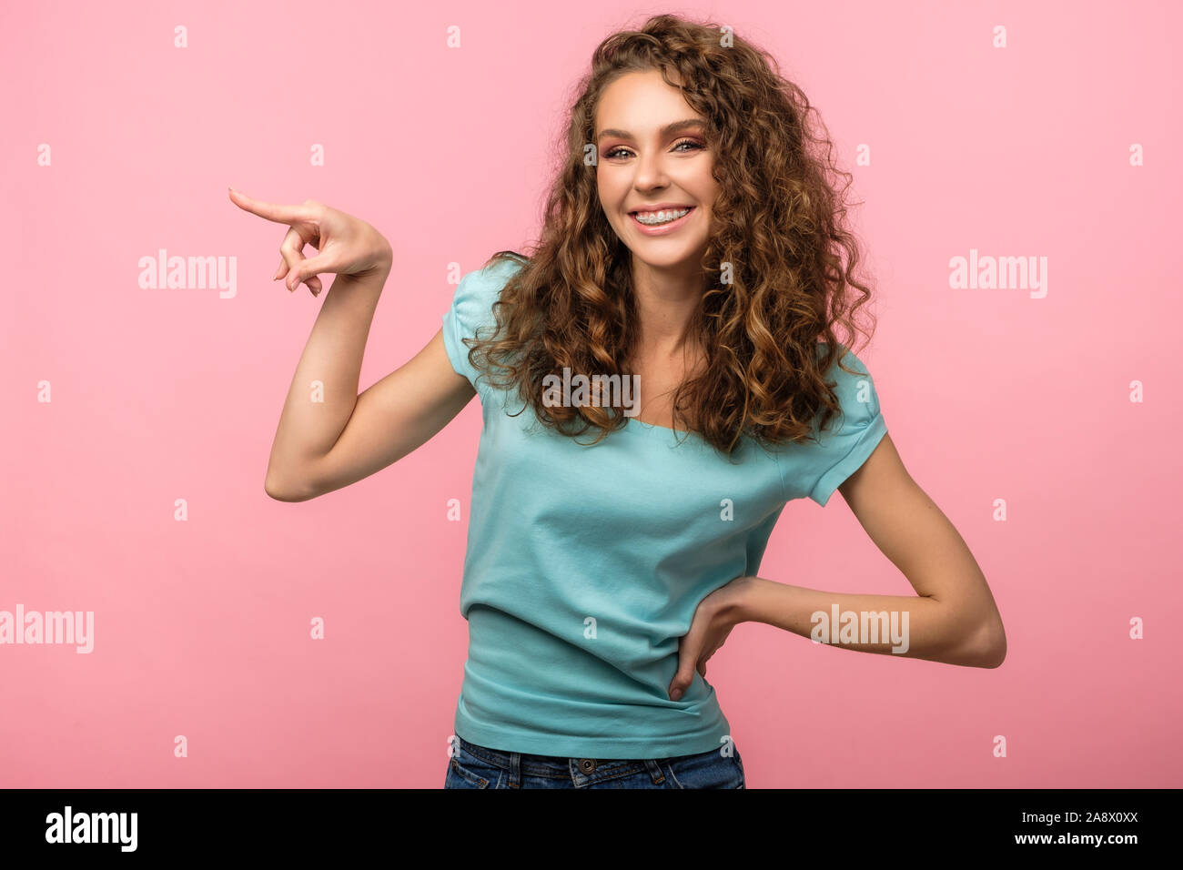 Pretty girl point her finger to left side of the picture isolated on ...