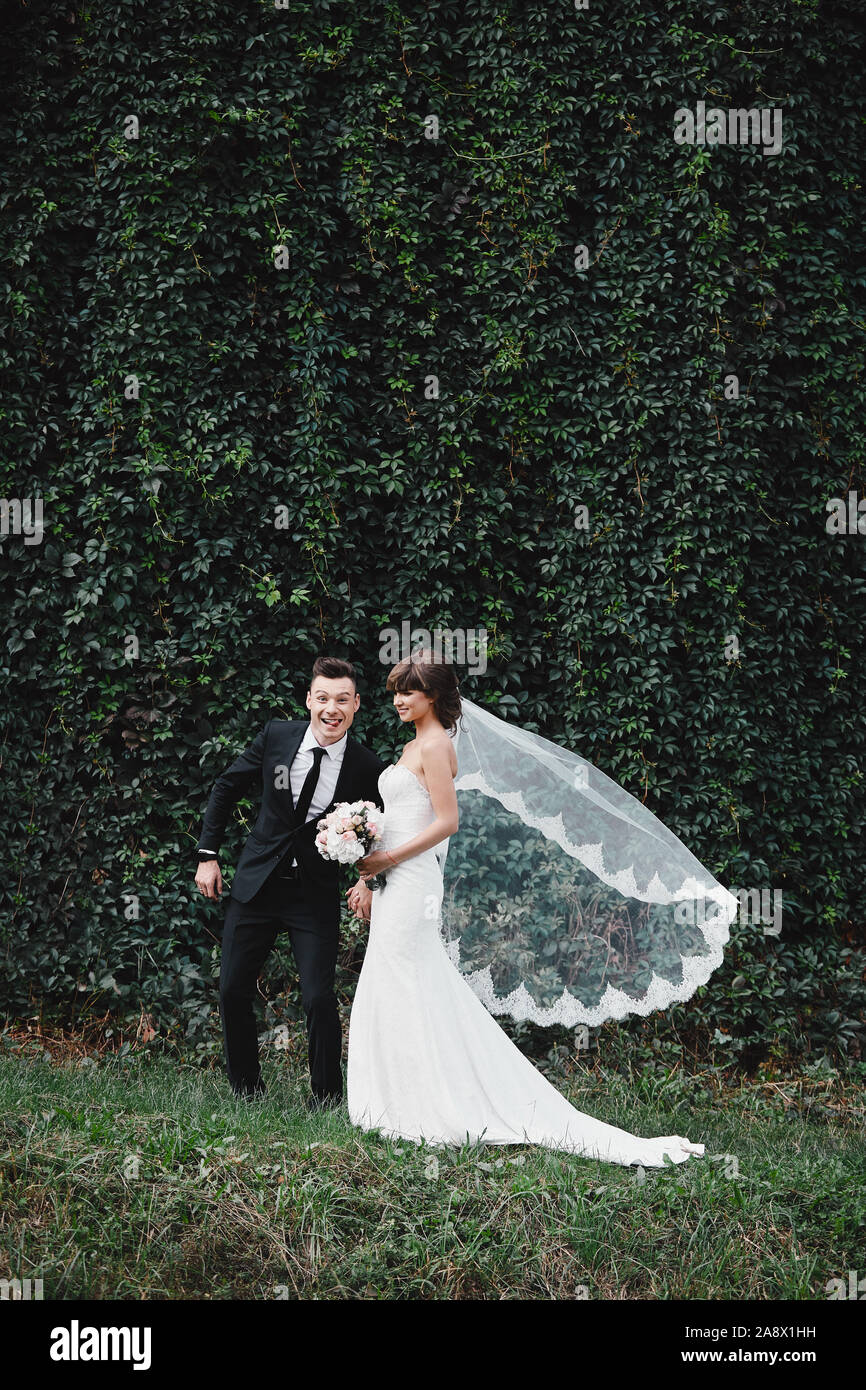 fun and crazy brides. happy gorgeous bride and stylish groom jumping ...