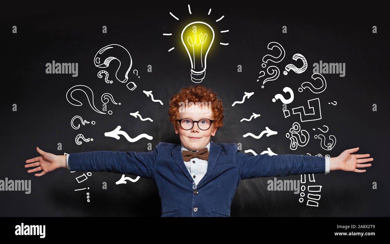 Little student child embracing on blackboard background with lightbulb ...