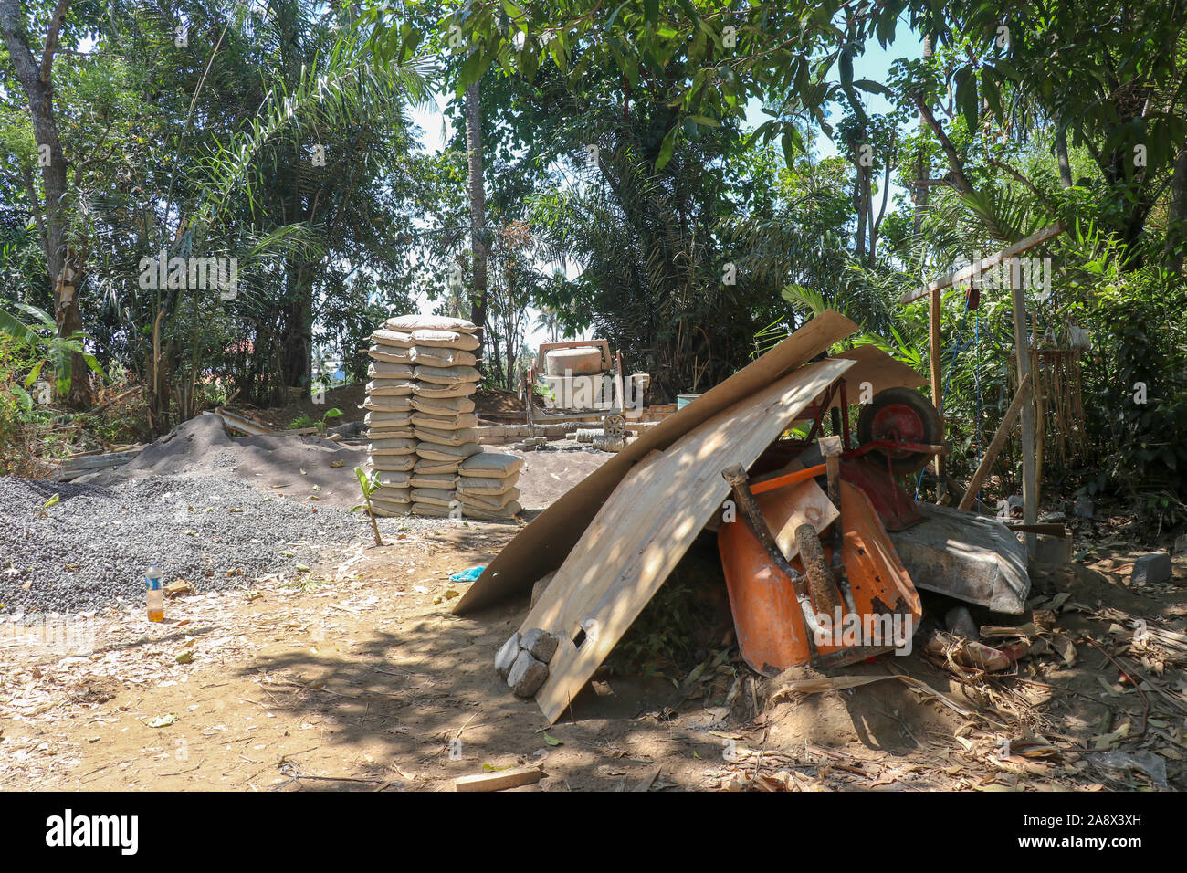 Construction site in the jungle. Work cart leaning against a pile of ...