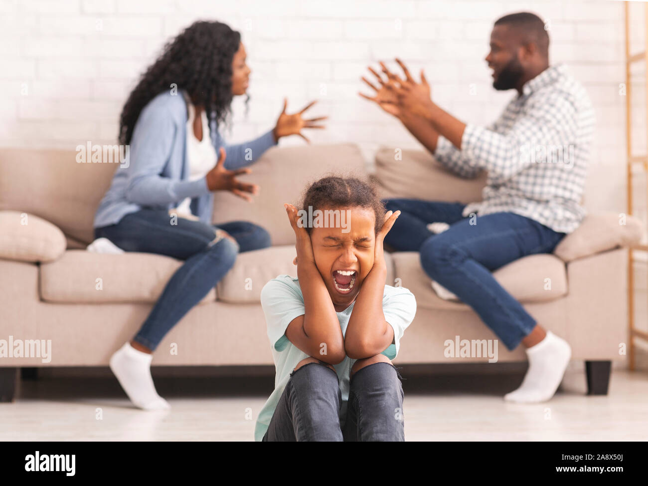 Little girl screaming and closing ears for not listening parents ...