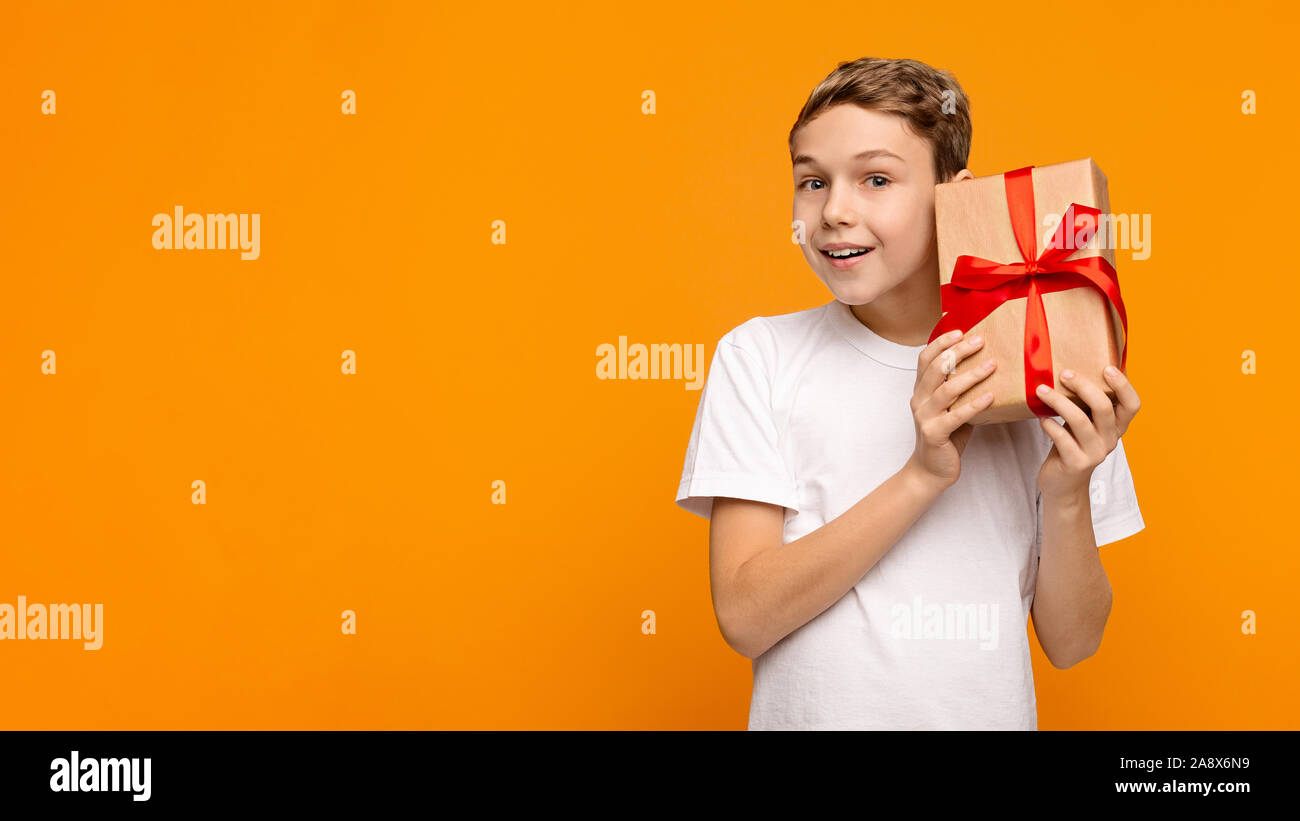 Curious boy shaking present box, trying to guess what inside Stock ...