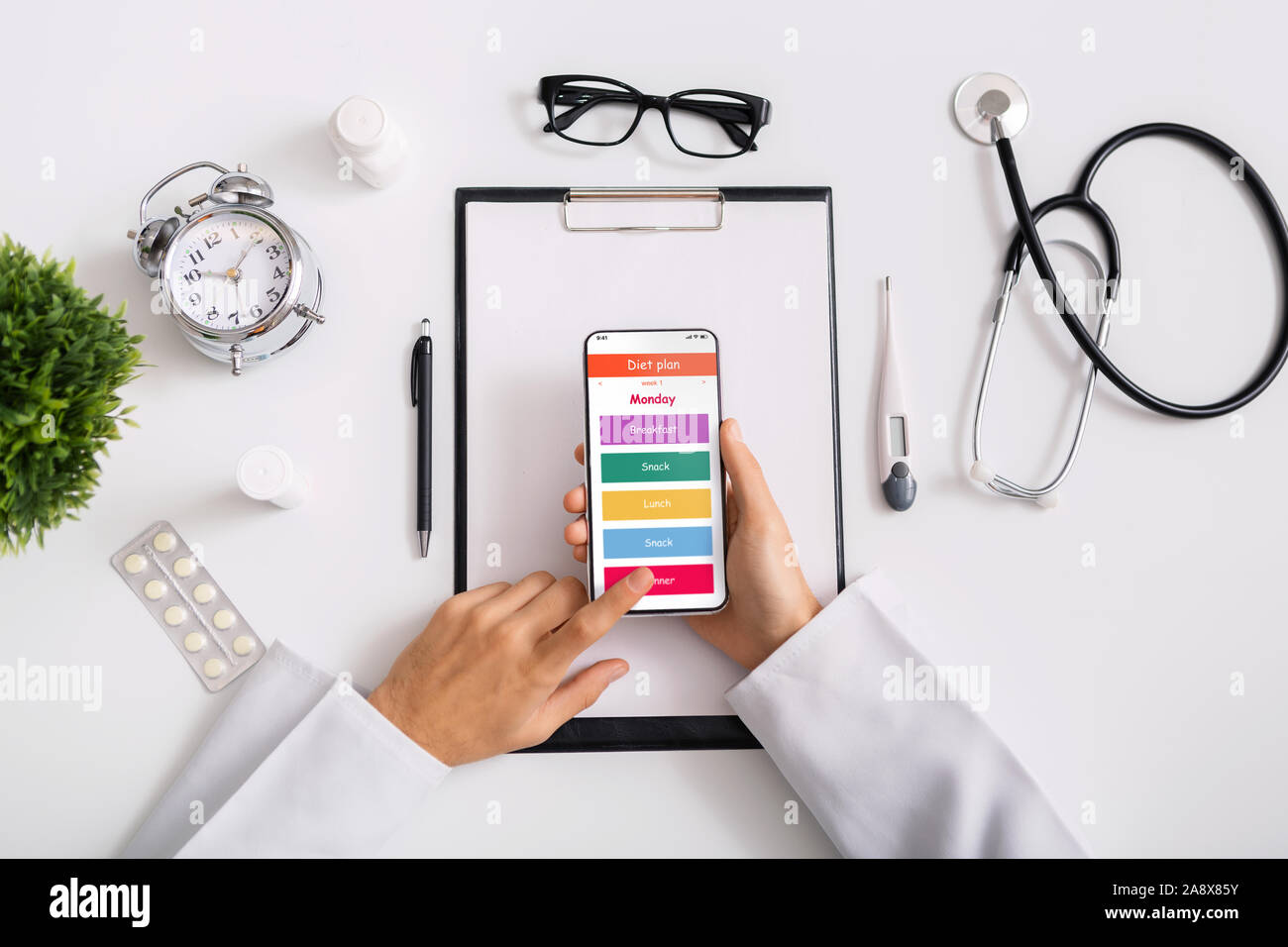 Doctor nutritionist using smartphone with opened daily diet plan ...