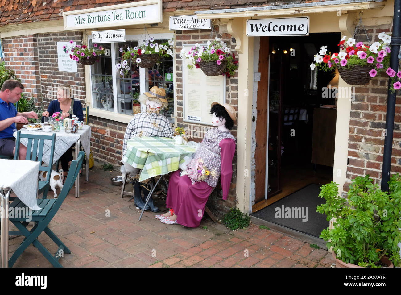 Outdoor summer lunch at a quaint tea room with straw dummy customers in ...