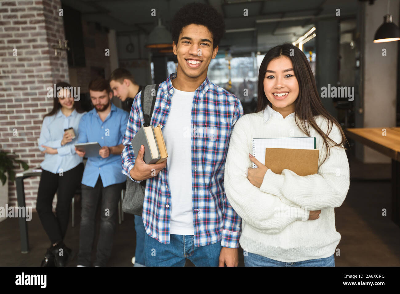 Student lifestyle. Smiling classmates posing in library Stock Photo - Alamy