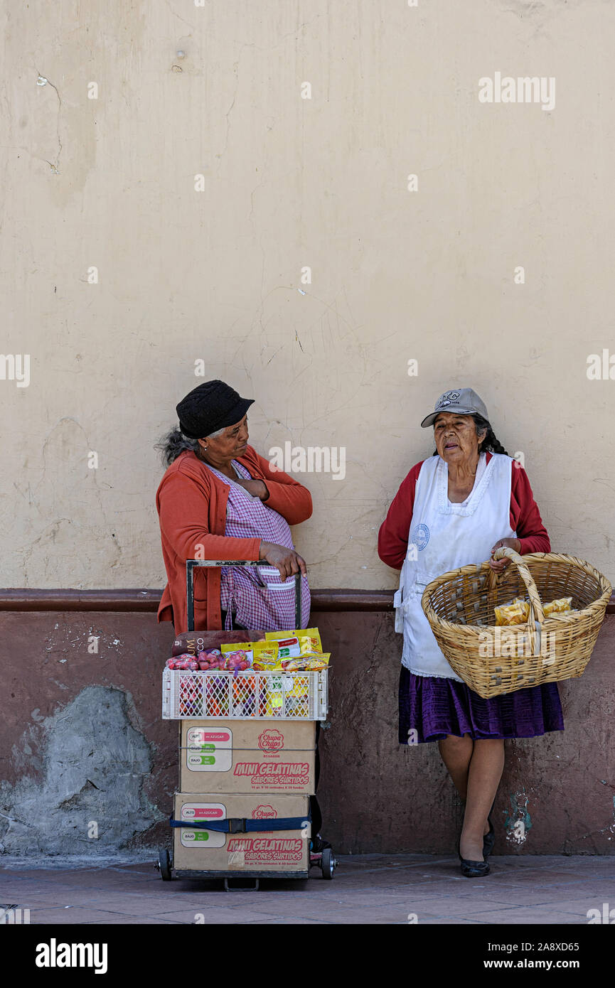 Two women talking and selling snacks on a street in Cuenca Ecuador ...